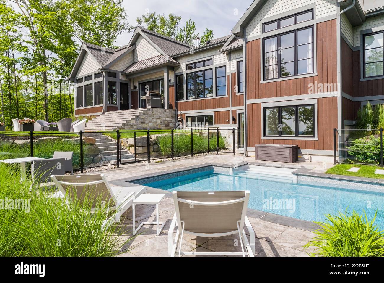 In-ground swimming pool and rear view of contemporary natural stone and ...
