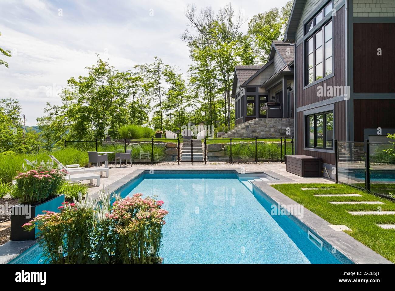In-ground swimming pool and rear view of contemporary natural stone and ...