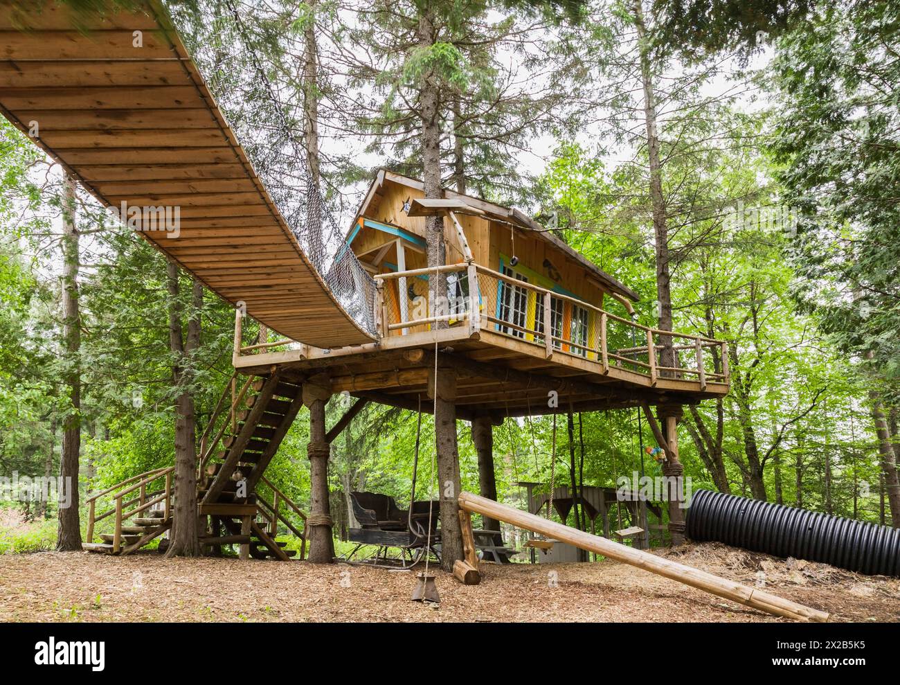Children's playground and fancy tree house with half log stairs and ...