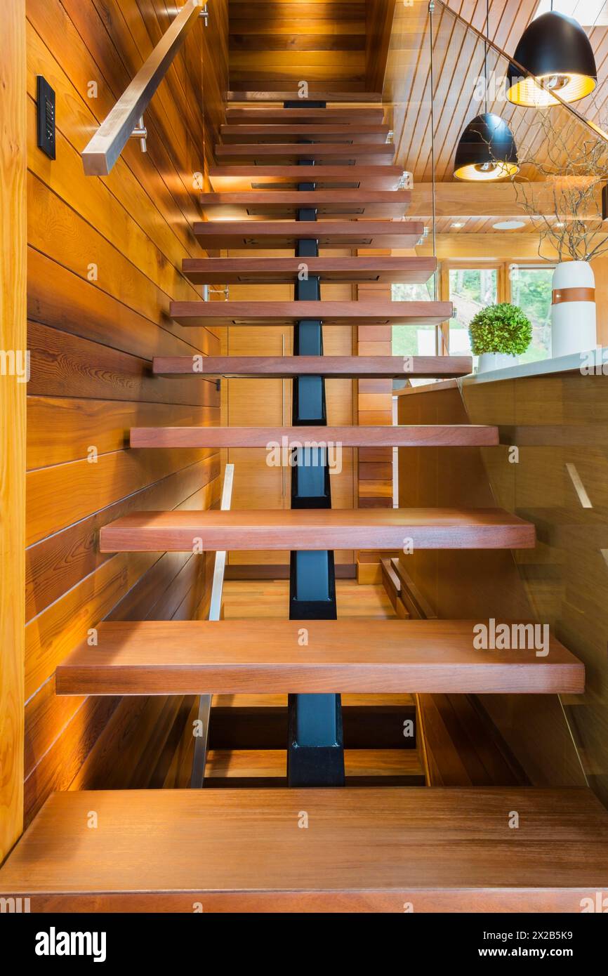 Looking up illuminated wooden staircase with opened steps and clear ...