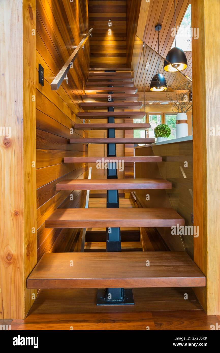 Looking up illuminated wooden staircase with opened steps and clear ...