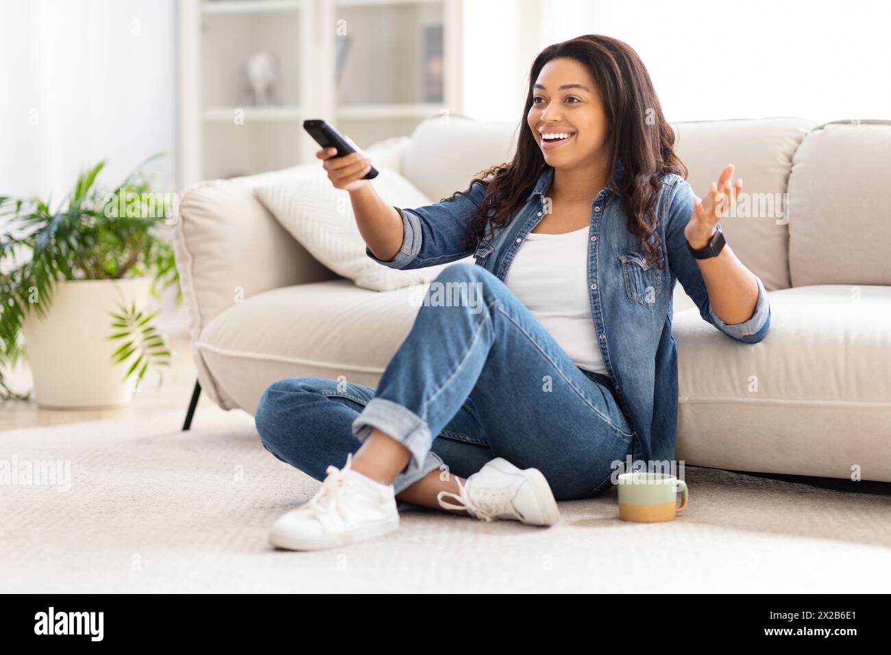 Woman Sitting on Floor Holding Remote Control, Watching TV Stock Photo ...
