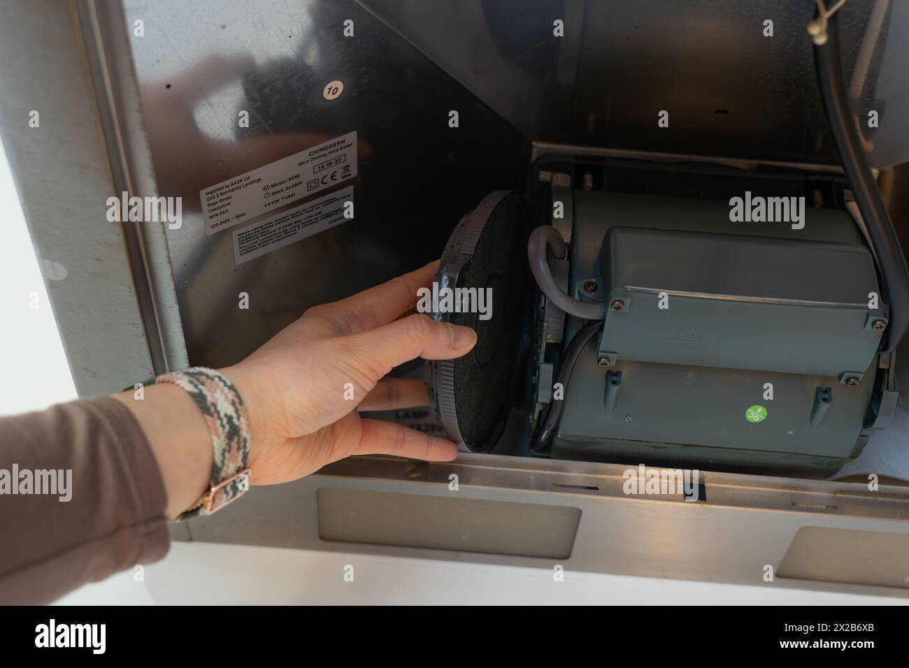 Person changing the filter in an oven hood, which contains activated ...
