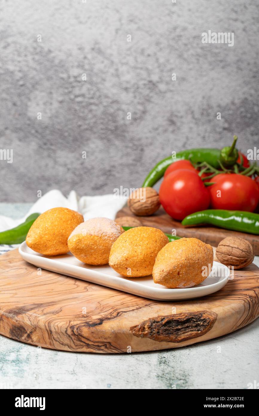 Uncooked frozen stuffed meatballs. Kibbeh or kibbeh on a wooden serving ...