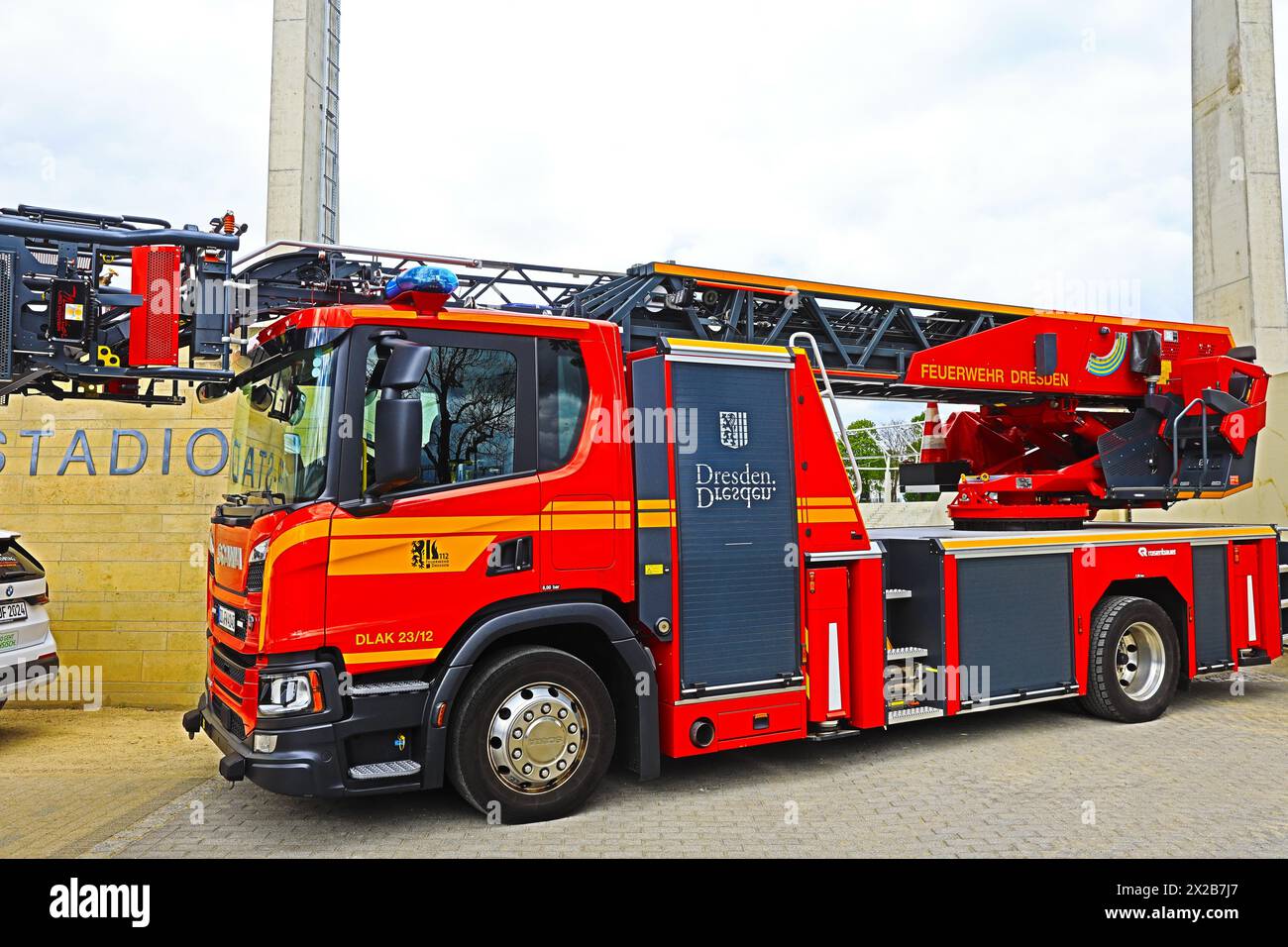 A red fire engine with a turntable ladder is parked in front of a ...