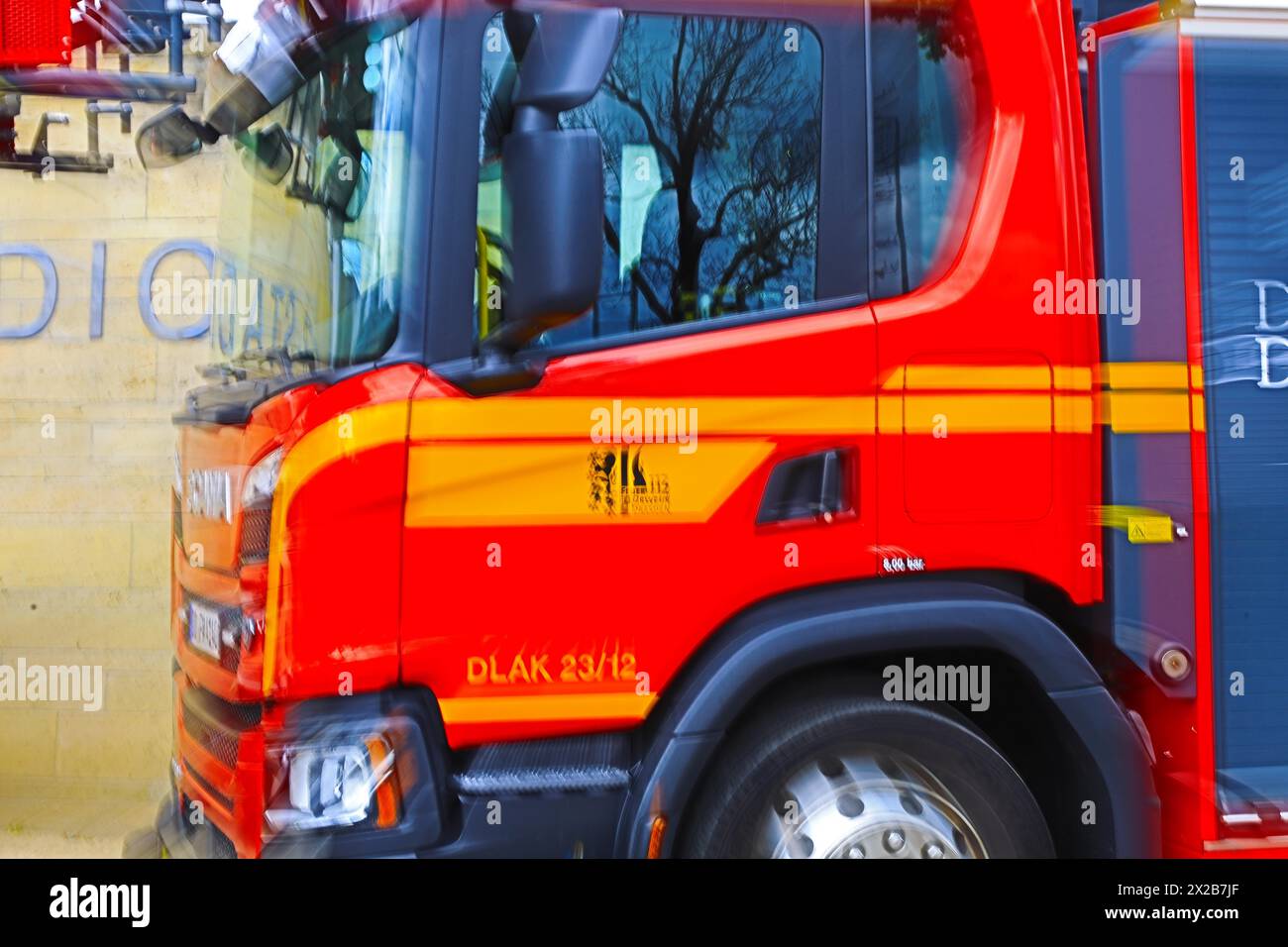 Side view of a red turntable ladder fire engine with yellow stripes ...
