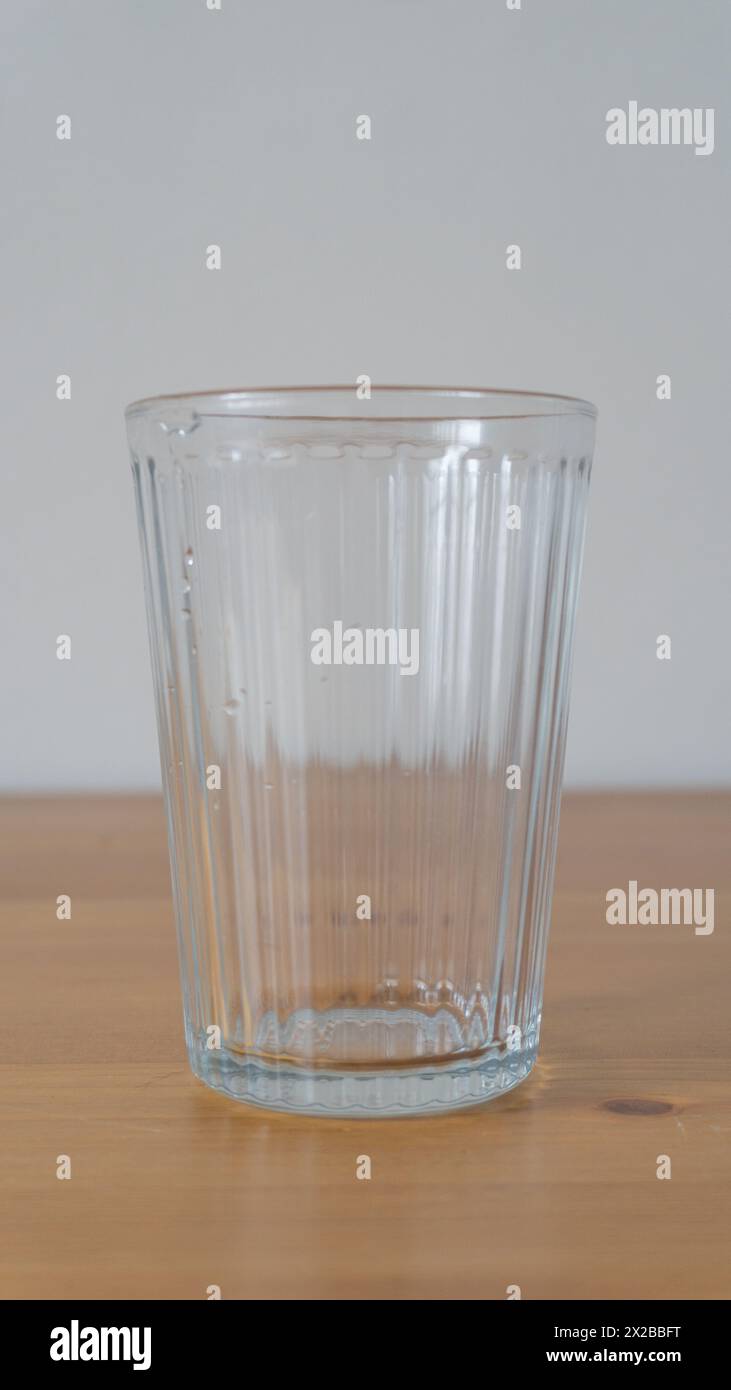Clear glass, ribbed texture, wooden backdrop Stock Photo - Alamy