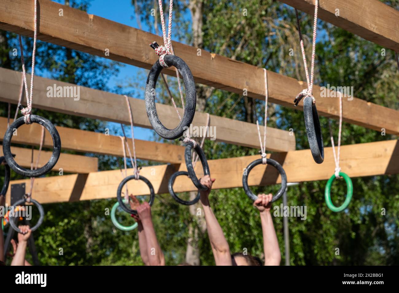 selective focus, athletes hands at a hanging obstacle at an obstacle ...