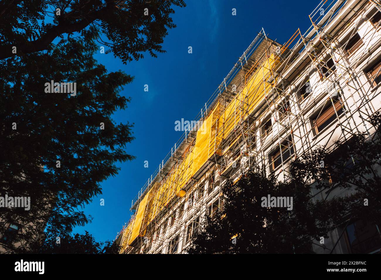 Yellow scaffolding construction on a building facade. Thermal ...