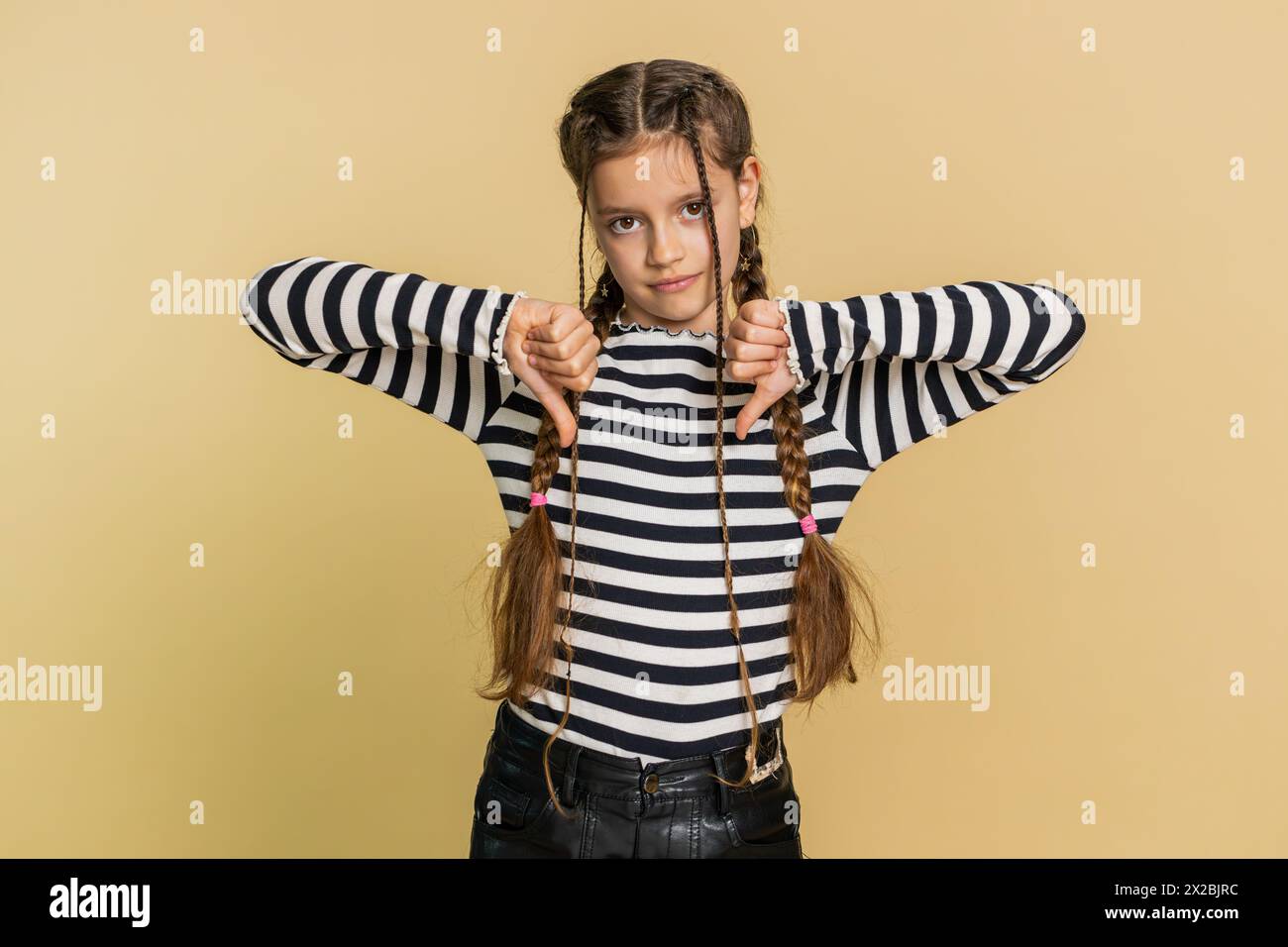 Dislike. Upset young preteen child girl kid showing thumbs down sign ...