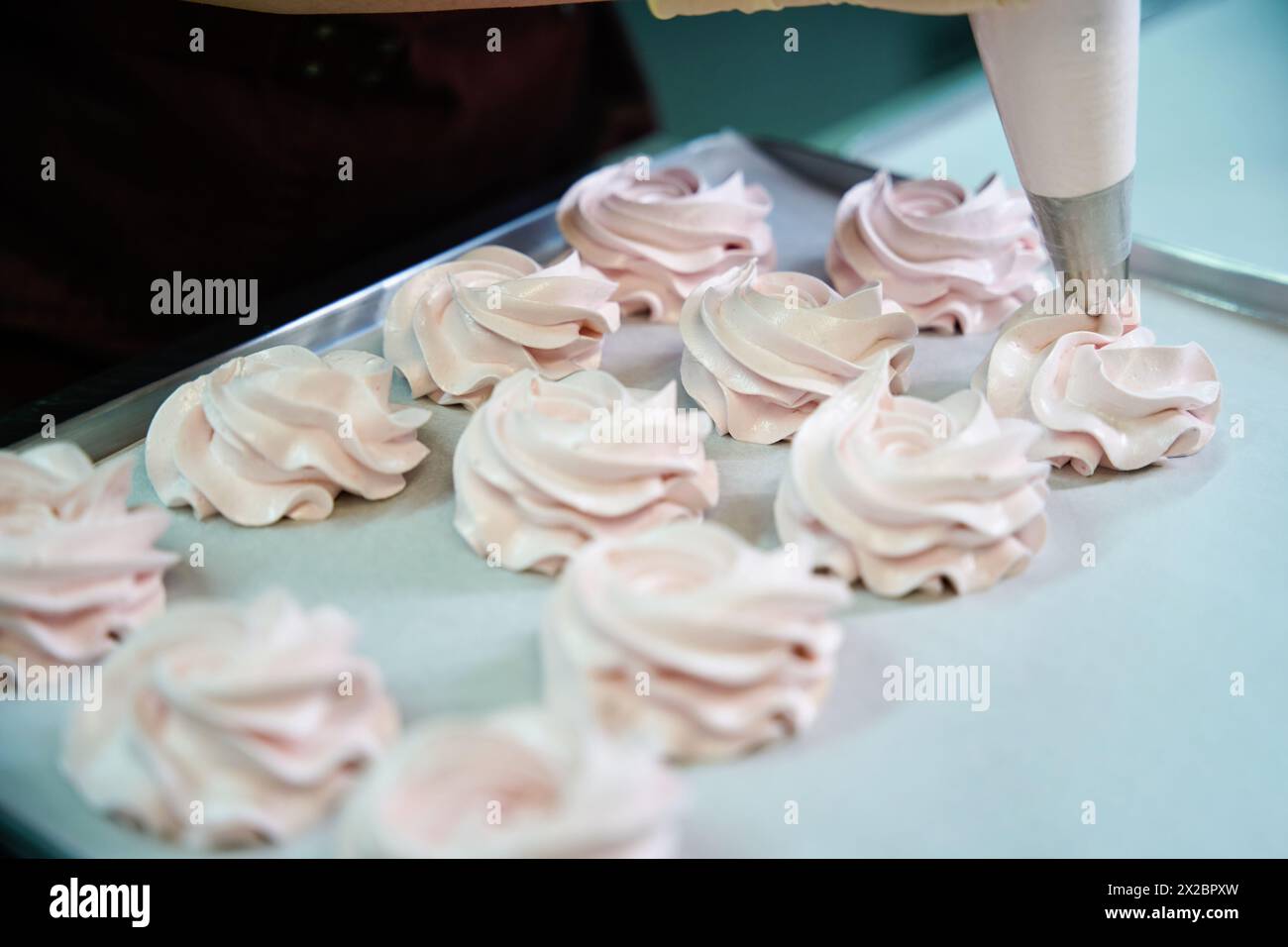 View to sweet pink mousse piping out from pastry bag Stock Photo - Alamy