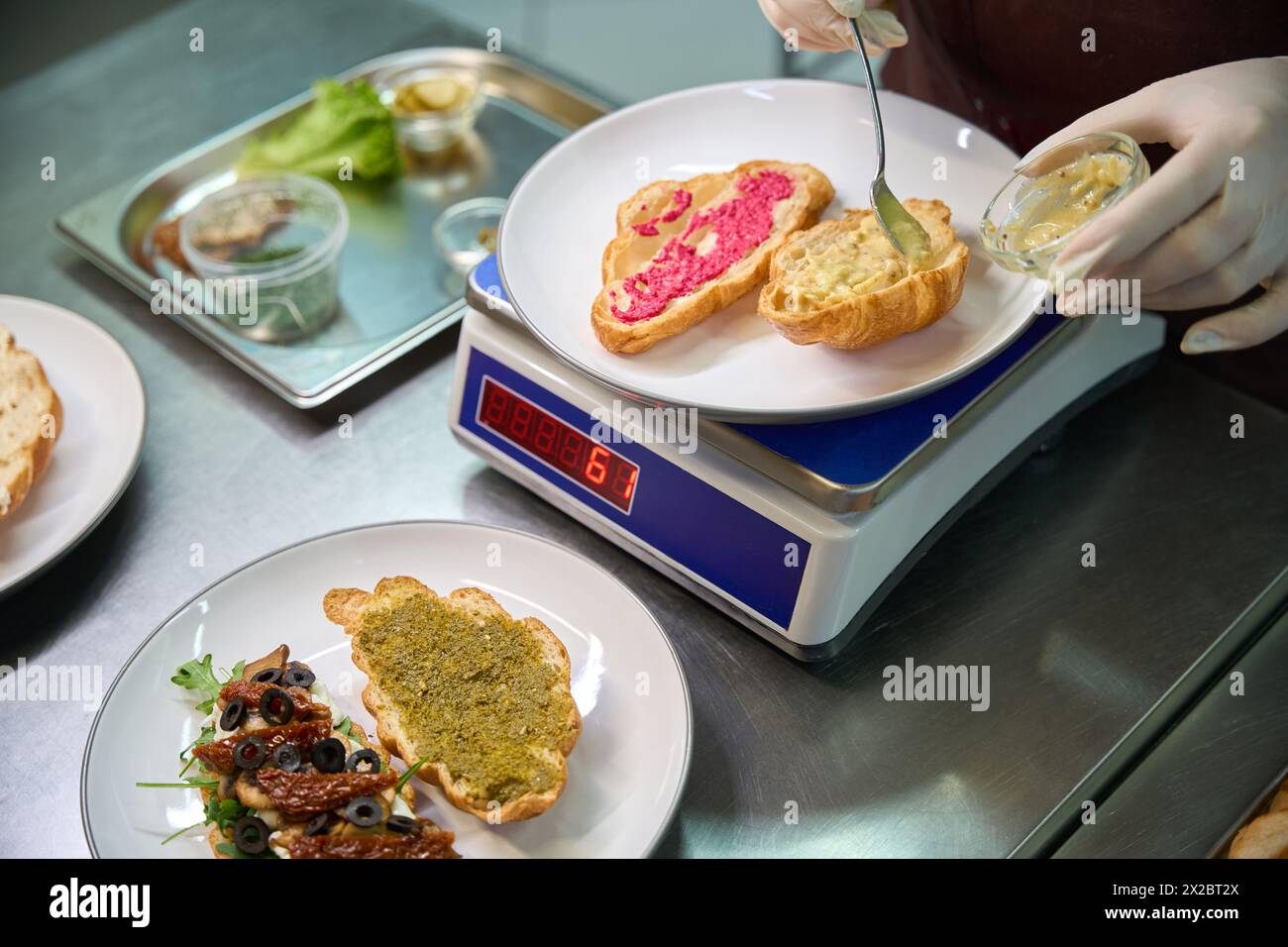 Woman cook adding sauces and checking weight of croissant sandwich ...