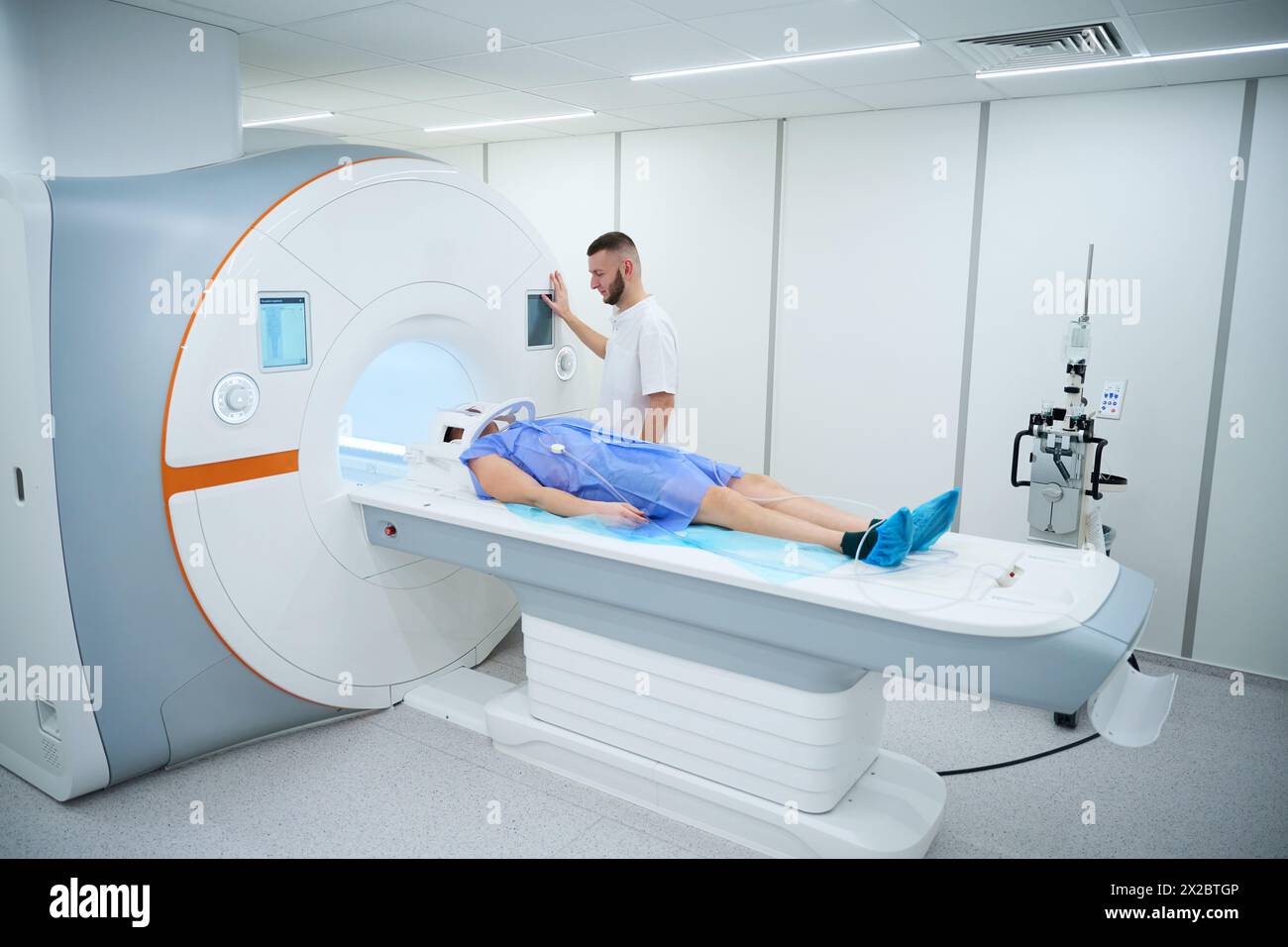 Doctor preparing man for contrast-enhanced brain magnetic resonance ...
