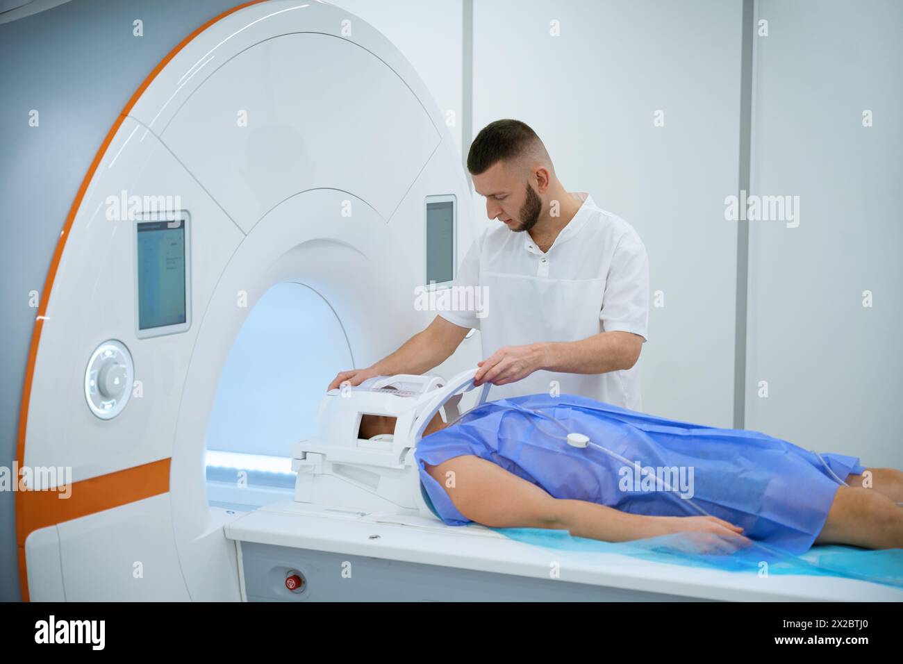 Radiographer preparing man for brain magnetic resonance imaging ...