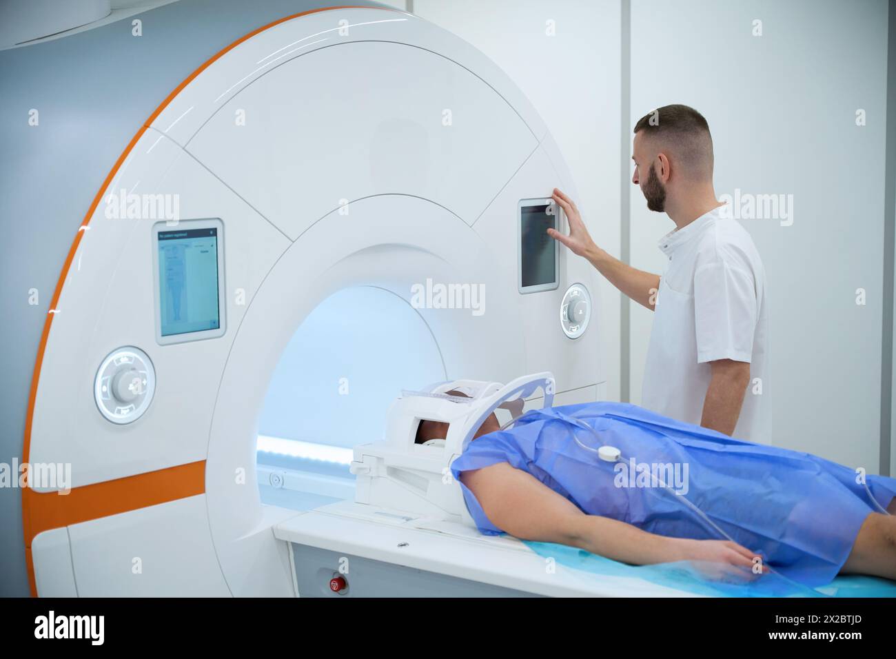 Technologist positioning outpatient for magnetic resonance imaging of ...