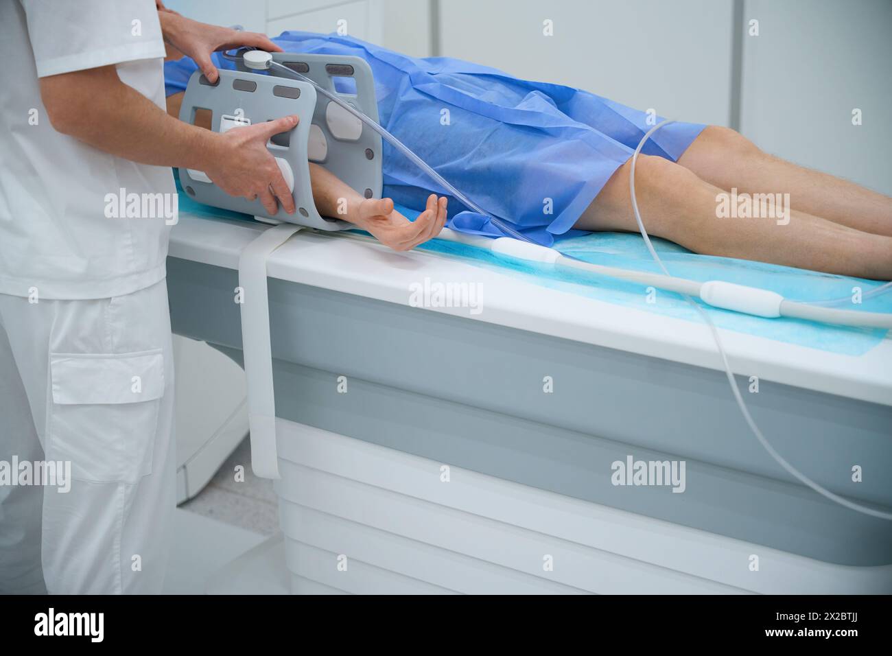 Medical professional preparing patient for magnetic resonance imaging ...