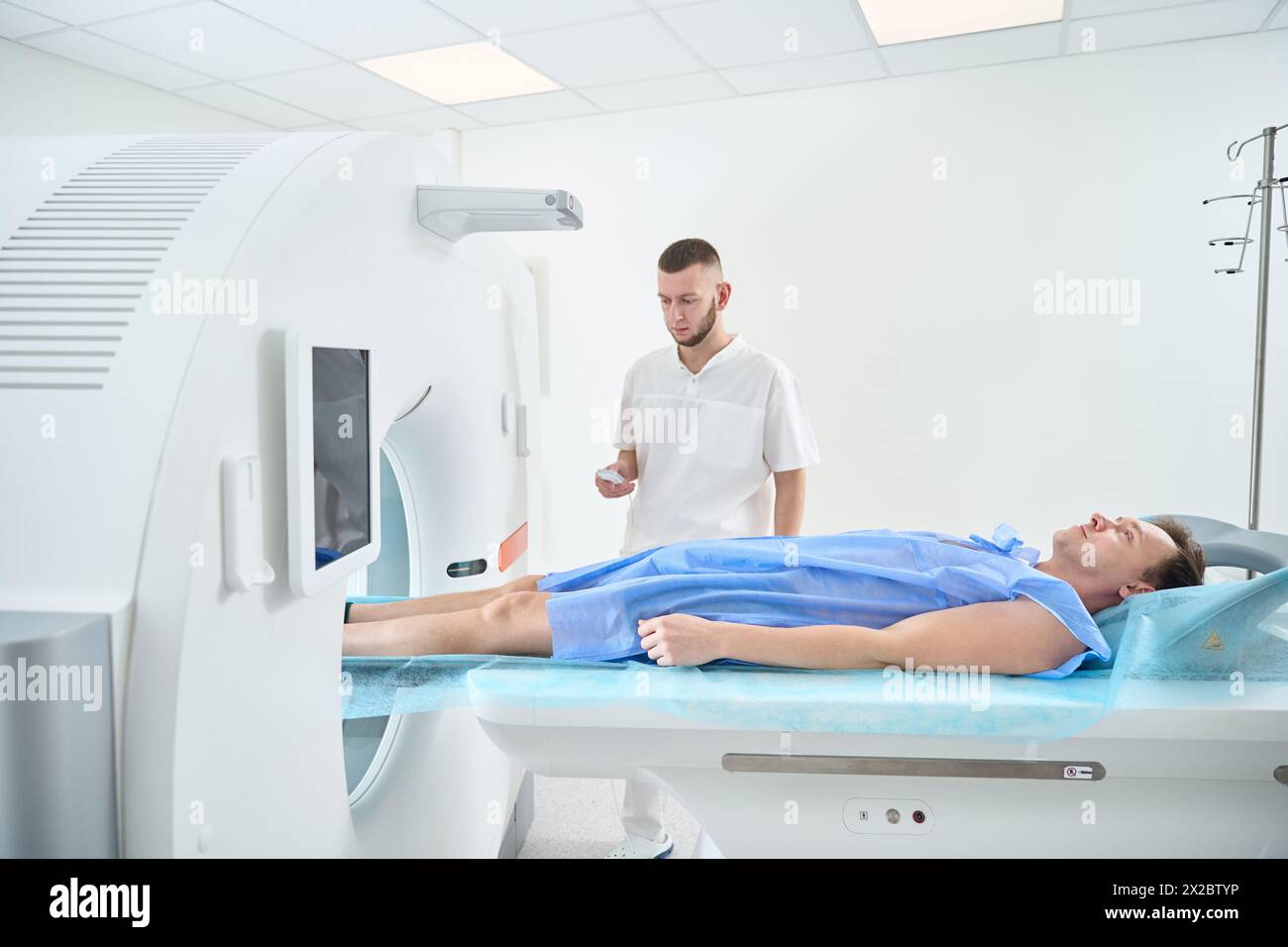Radiographer is positioning patient for computed tomography of lower ...