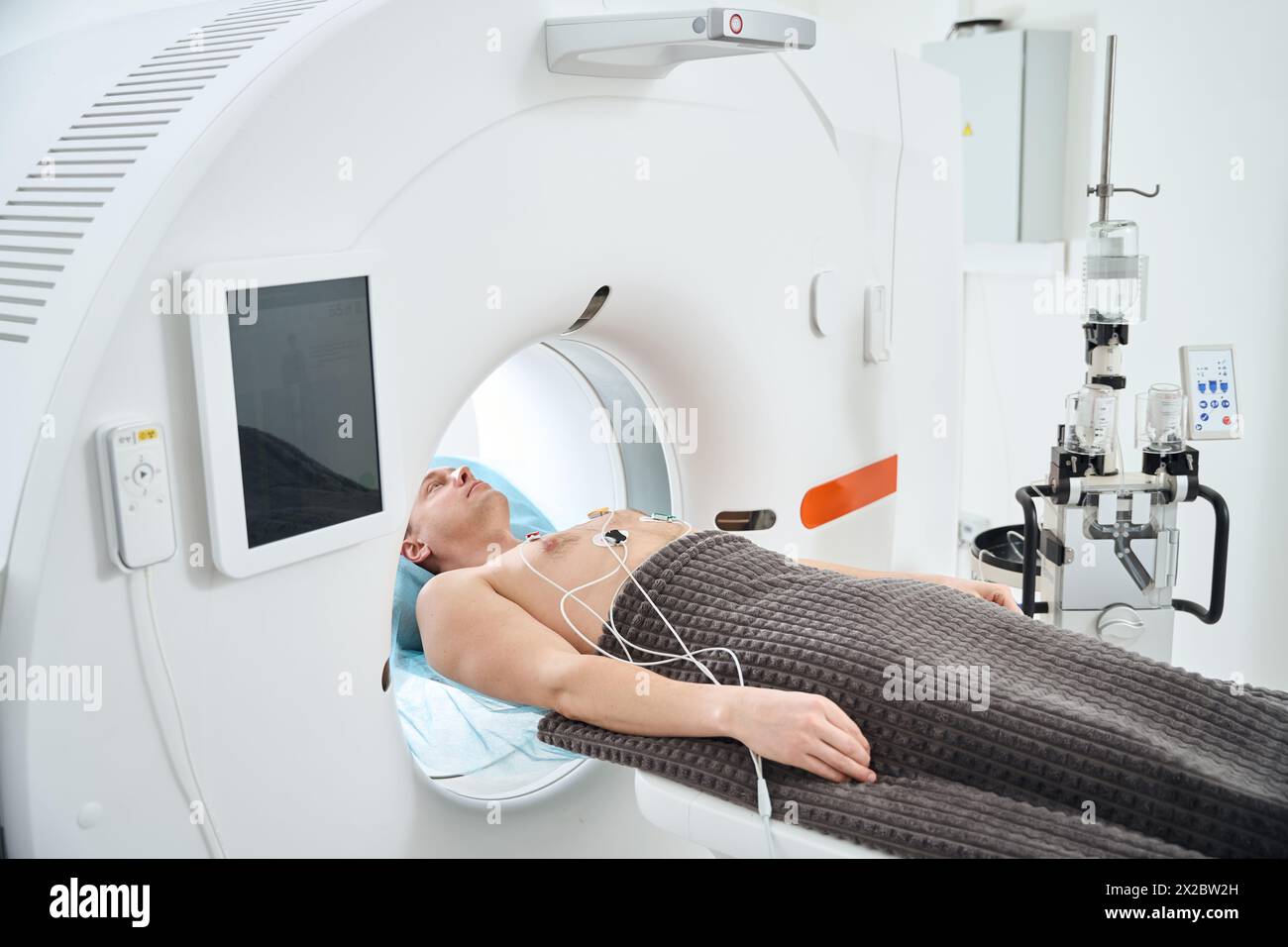 Man undergoing contrast-enhanced ECG-gated coronary CT angiography ...