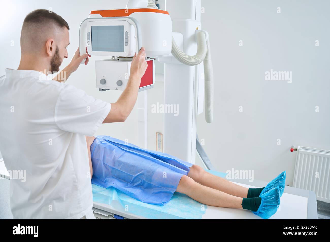 Radiologic technologist is preparing adult man for digital abdominal ...