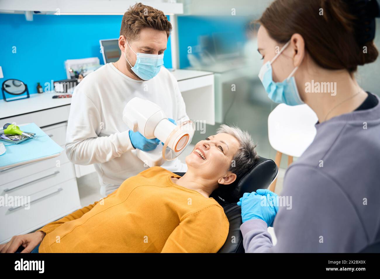 Experienced doctor making x-ray using portable dental tool Stock Photo ...