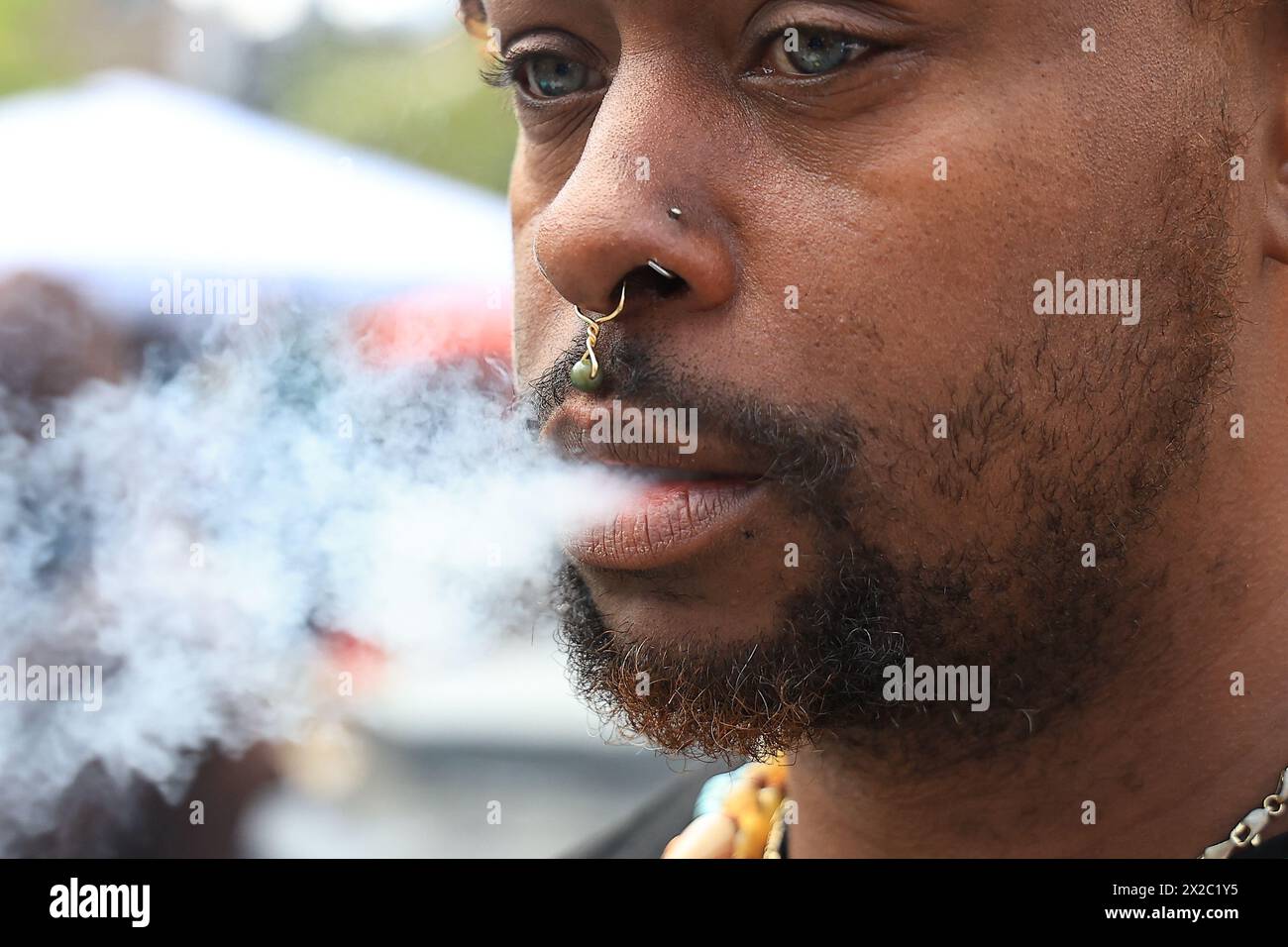 A man exhales smoke while smoking weed at the 420 Festivities at ...