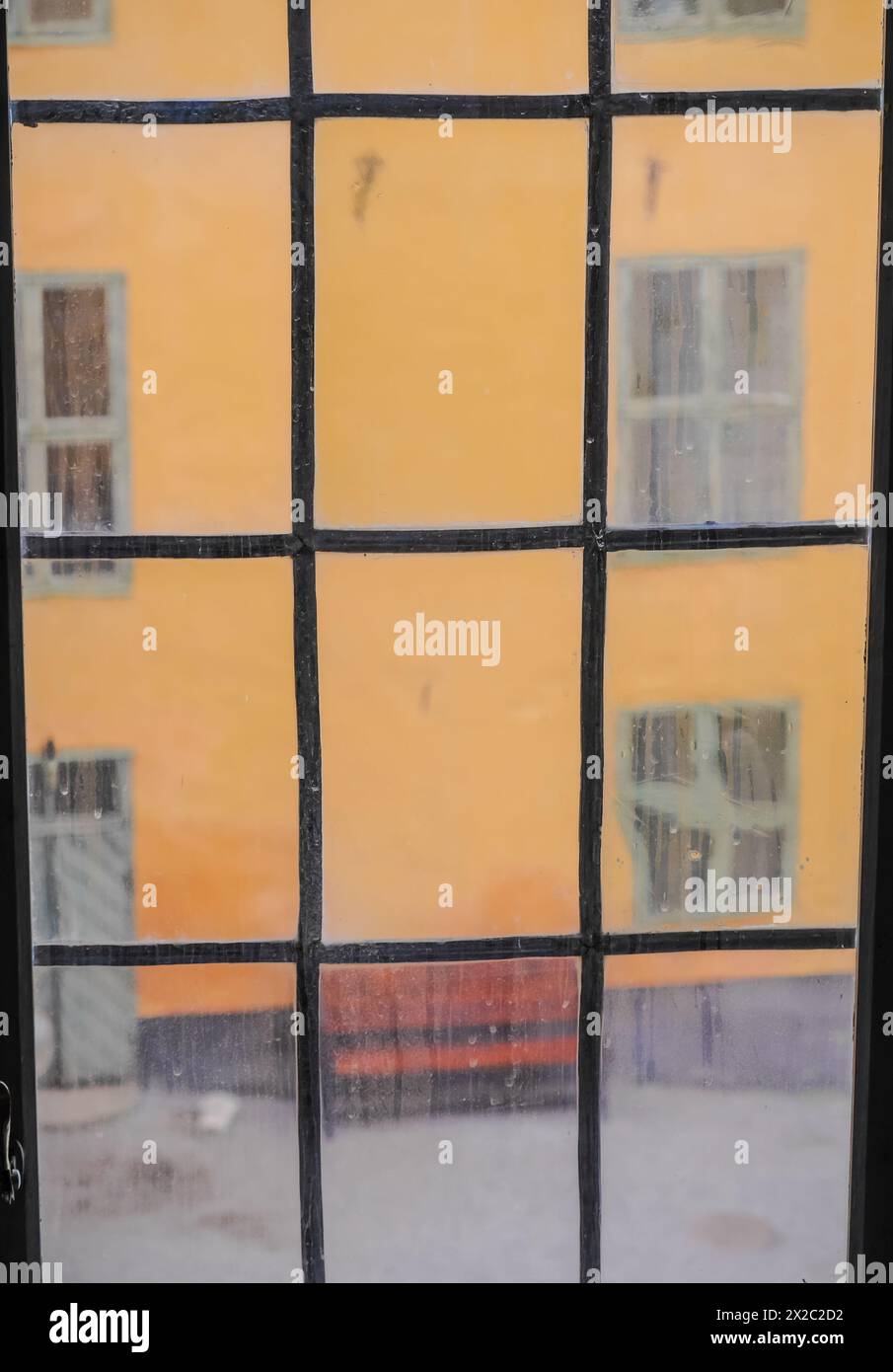 Yellow coloured wall of Wenngarn castle with windows and door, seen ...