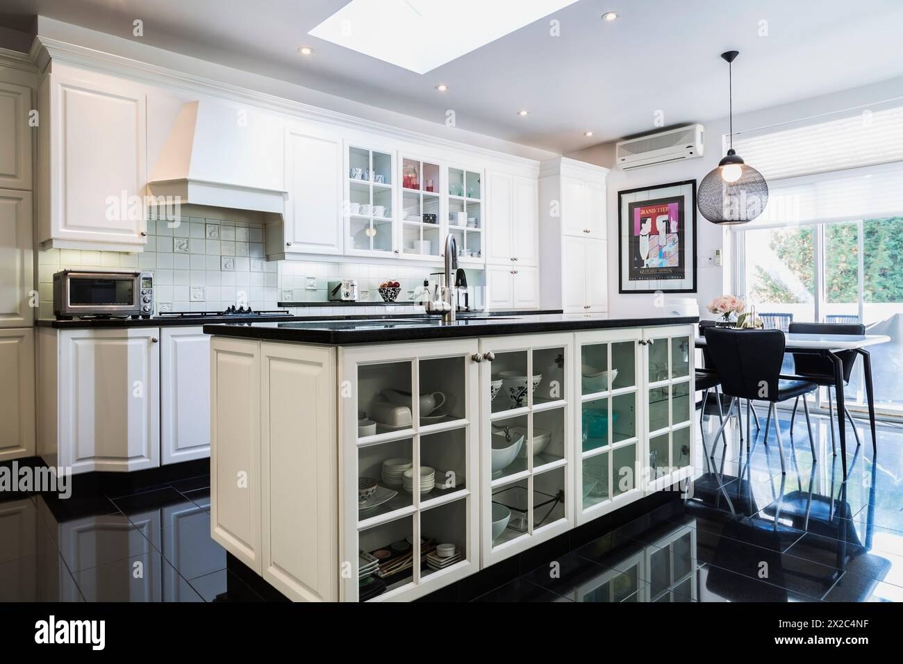 White wood and glass pane island with black granite countertop and ...