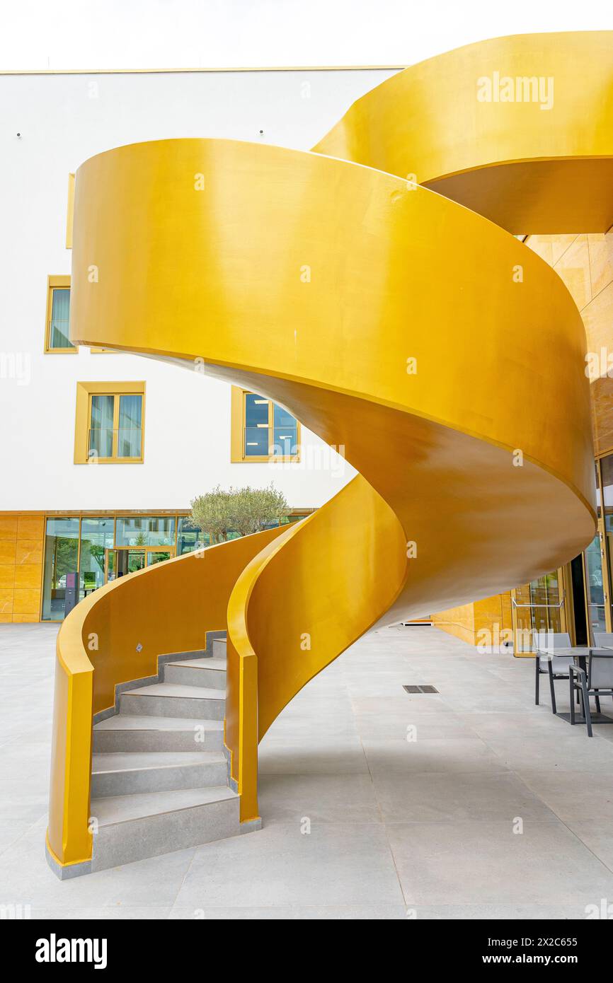 Snail-shaped concrete exterior stairs painted in gold.Tirana-Albania ...