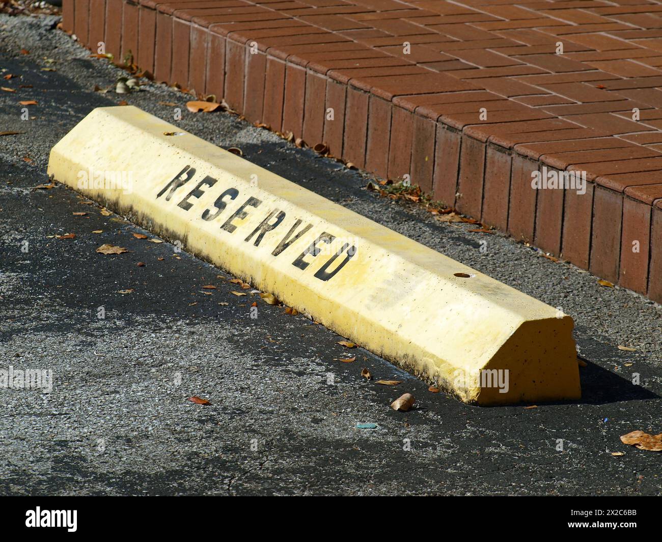 Yellow bumper of a reserved spot in a parking lot Stock Photo - Alamy
