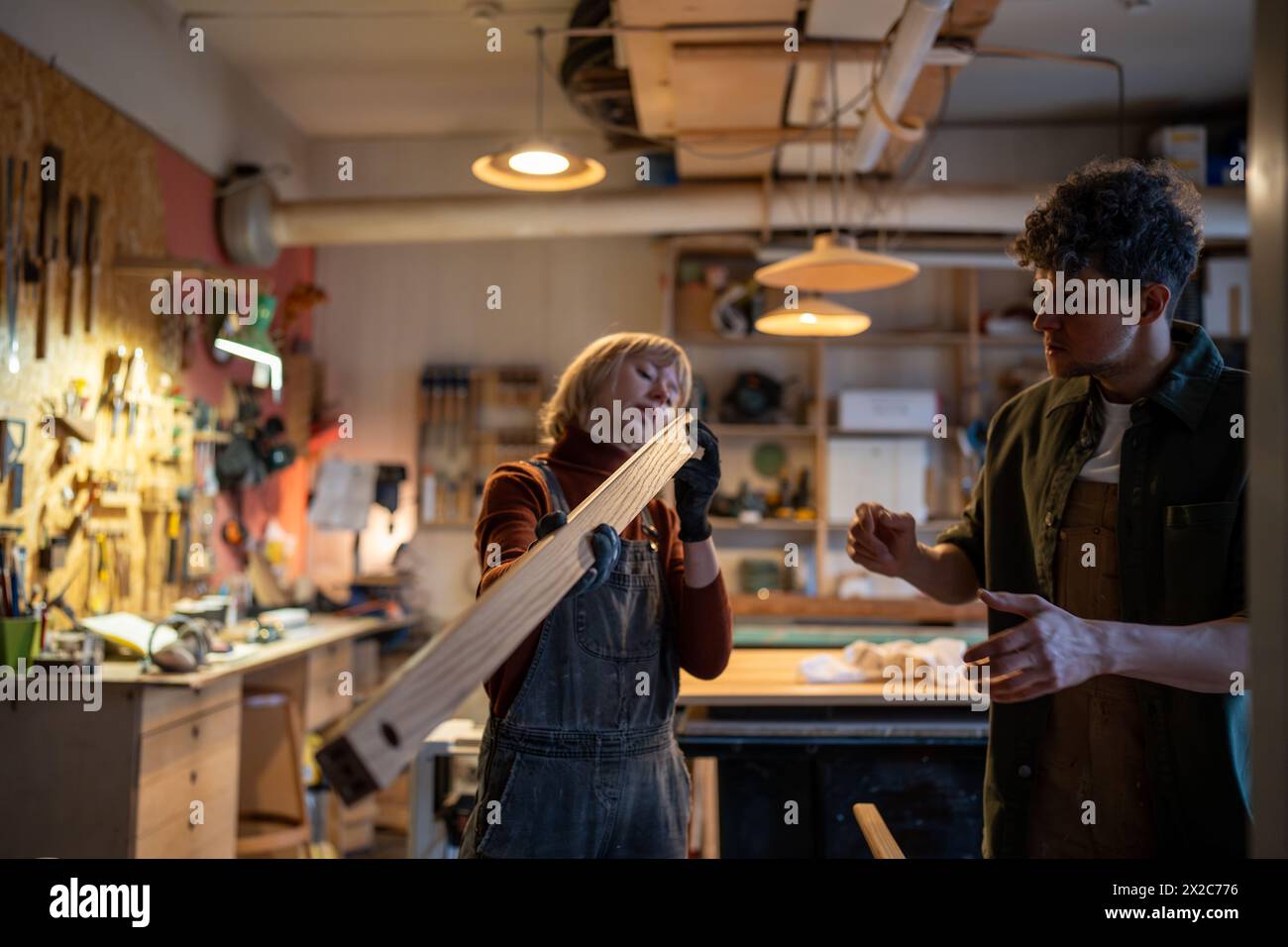 Teamwork, couple of carpenters in joinery workshop examines wooden ...