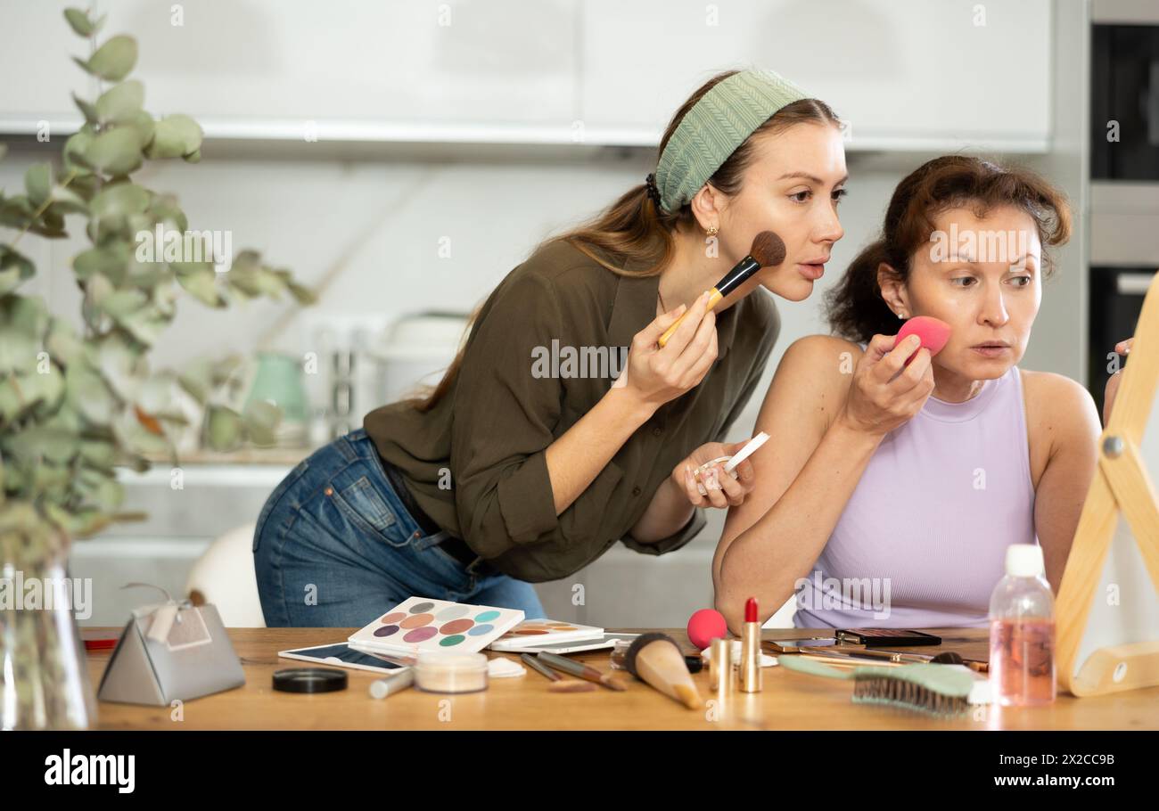 Mother applying makeup to her daughter hi-res stock photography and ...