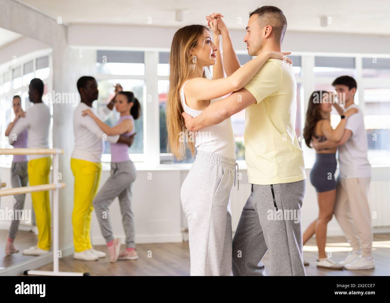 Group of men and women of different nationalities learn to dance the ...