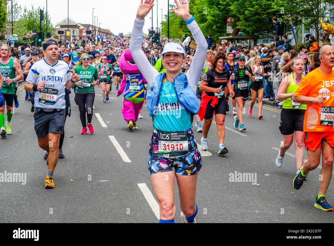 Female runner spreads raises her arms as she poses for photograph ...