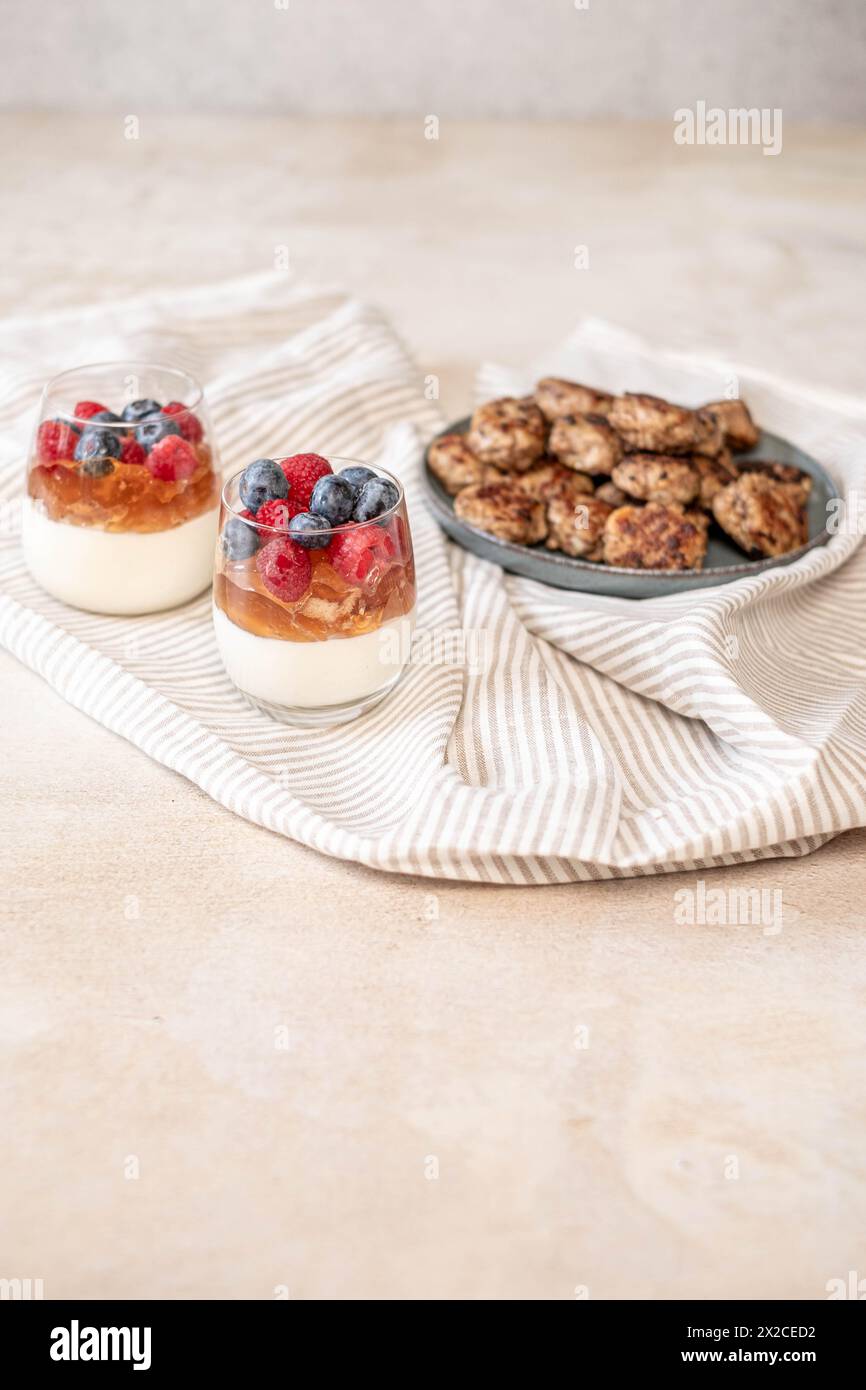 Gourmet meatballs on a rustic plate with a parfait of berries ...