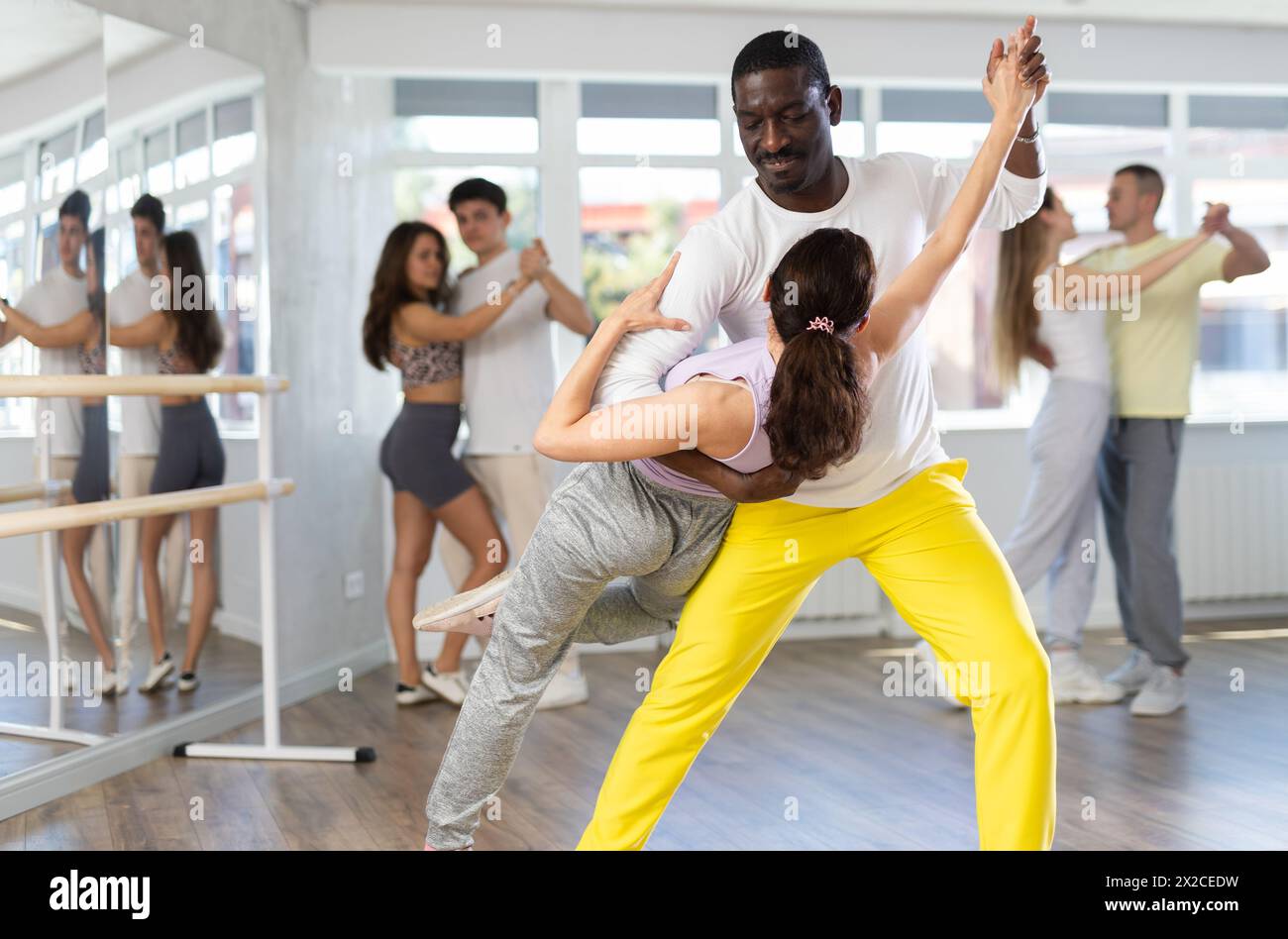 Group of men and women of different nationalities learn to dance the ...