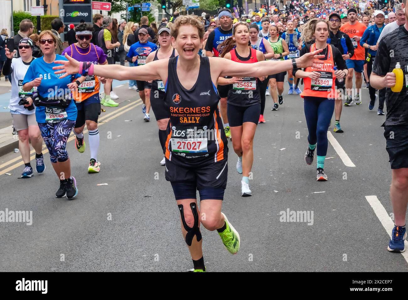 Female runner spreads her arms wide as she poses for photograph during ...