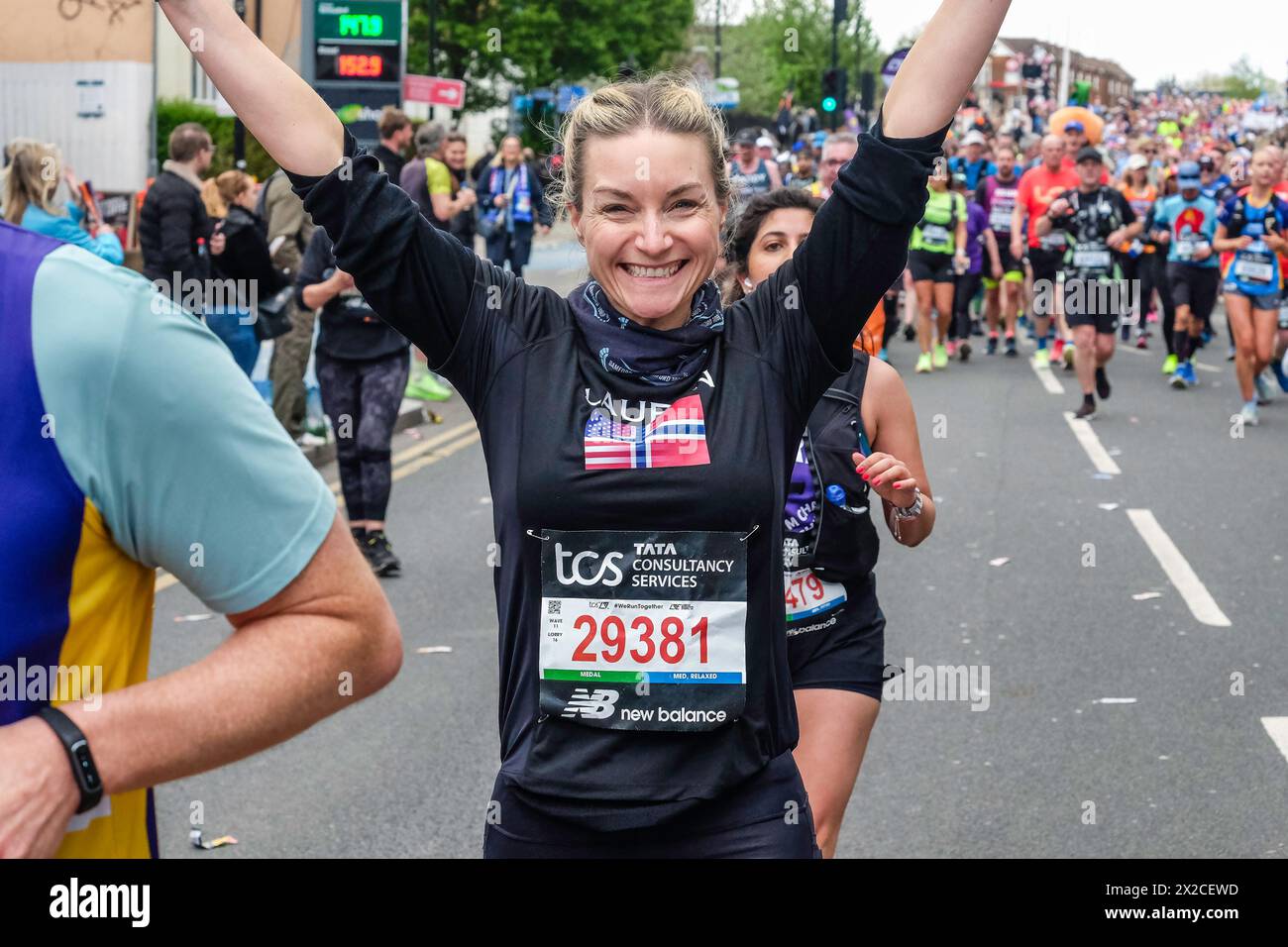 Female runner spreads raises her arms as she poses for photograph ...