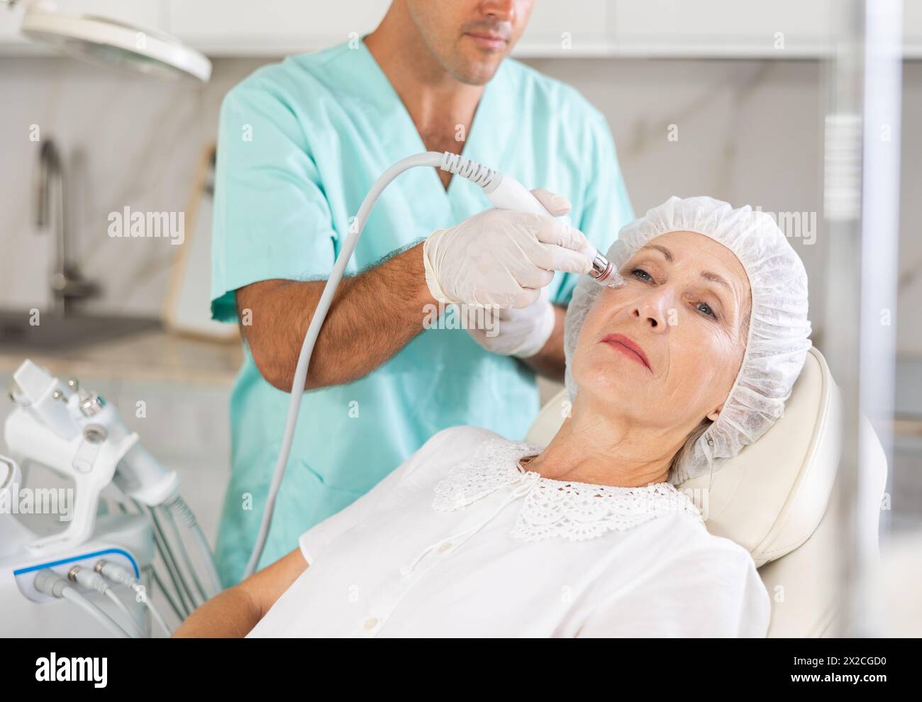 Mature woman getting facial deep hydration procedure from experienced ...