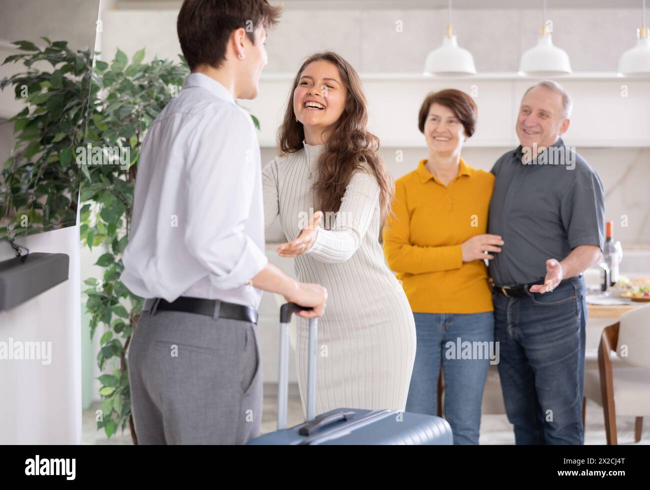 Young wife excitedly greeting husband returning from trip Stock Photo ...