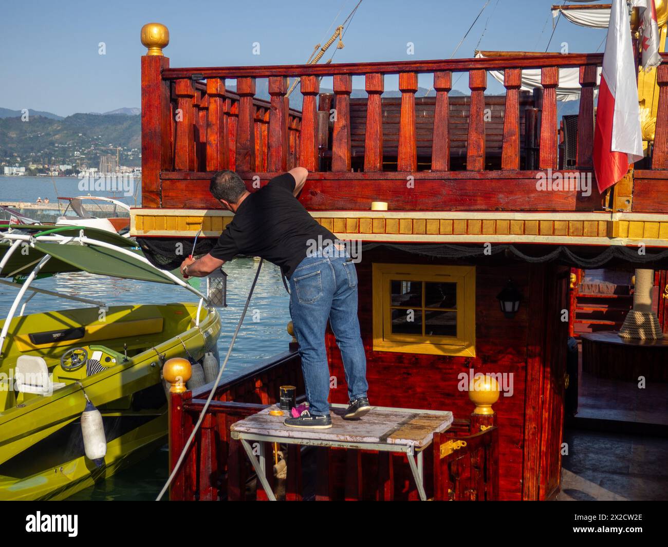 A pleasure boat made to look like a pirate ship. A worker works on the ...