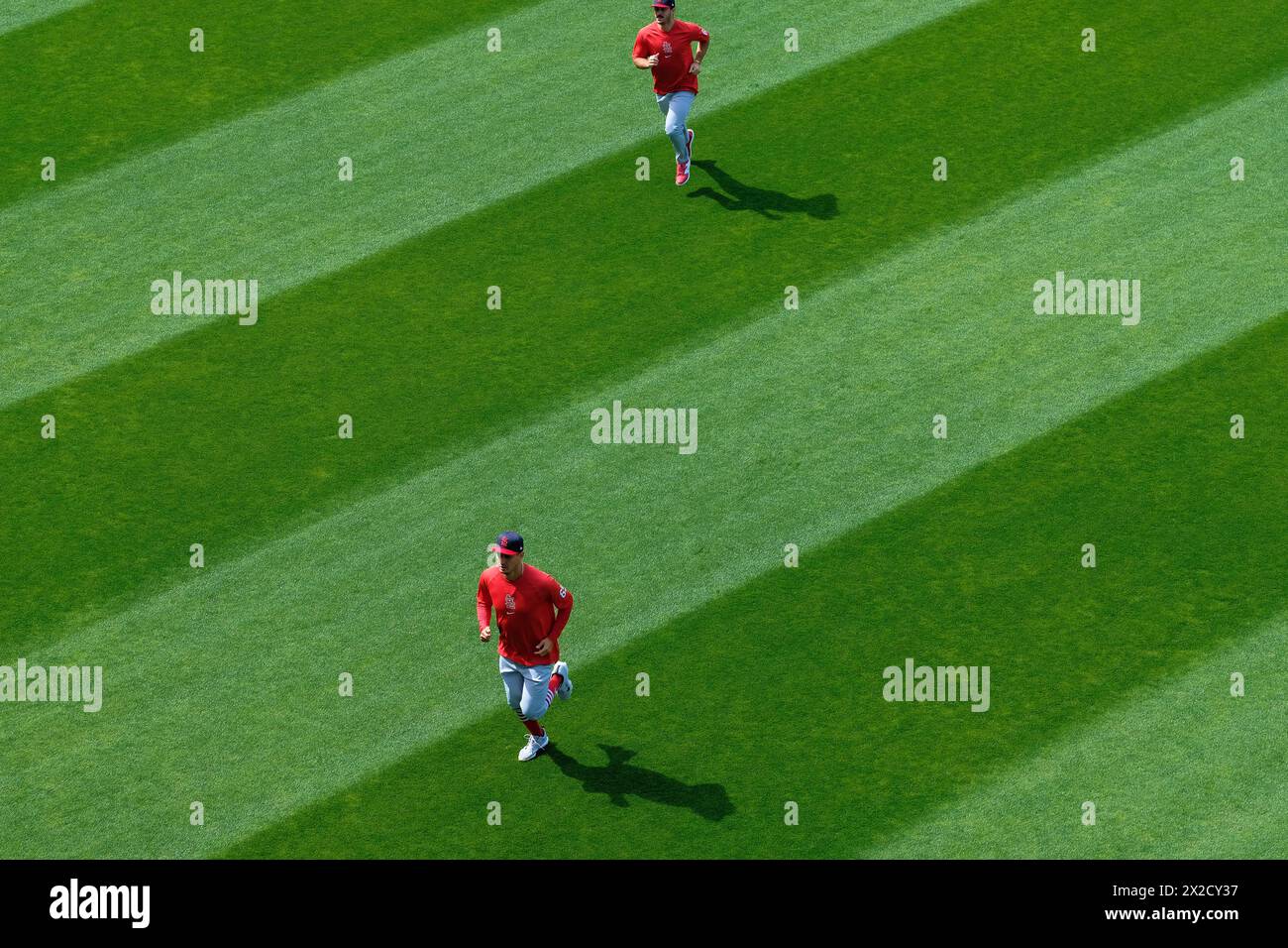 Two baseball players jogging and warming up before a game on the green ...