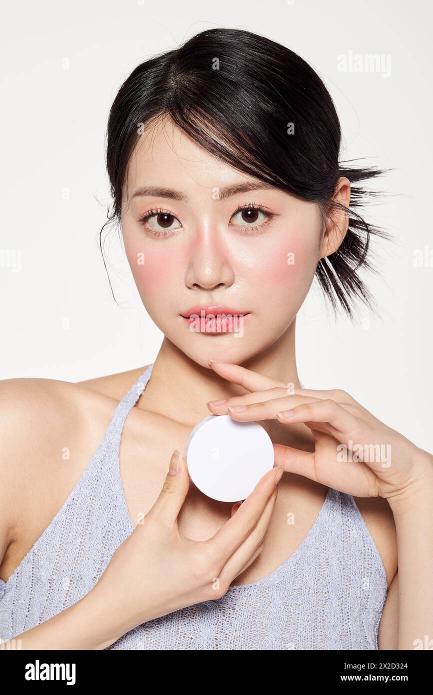 Asian woman wearing makeup and holding cushion compacts Stock Photo - Alamy