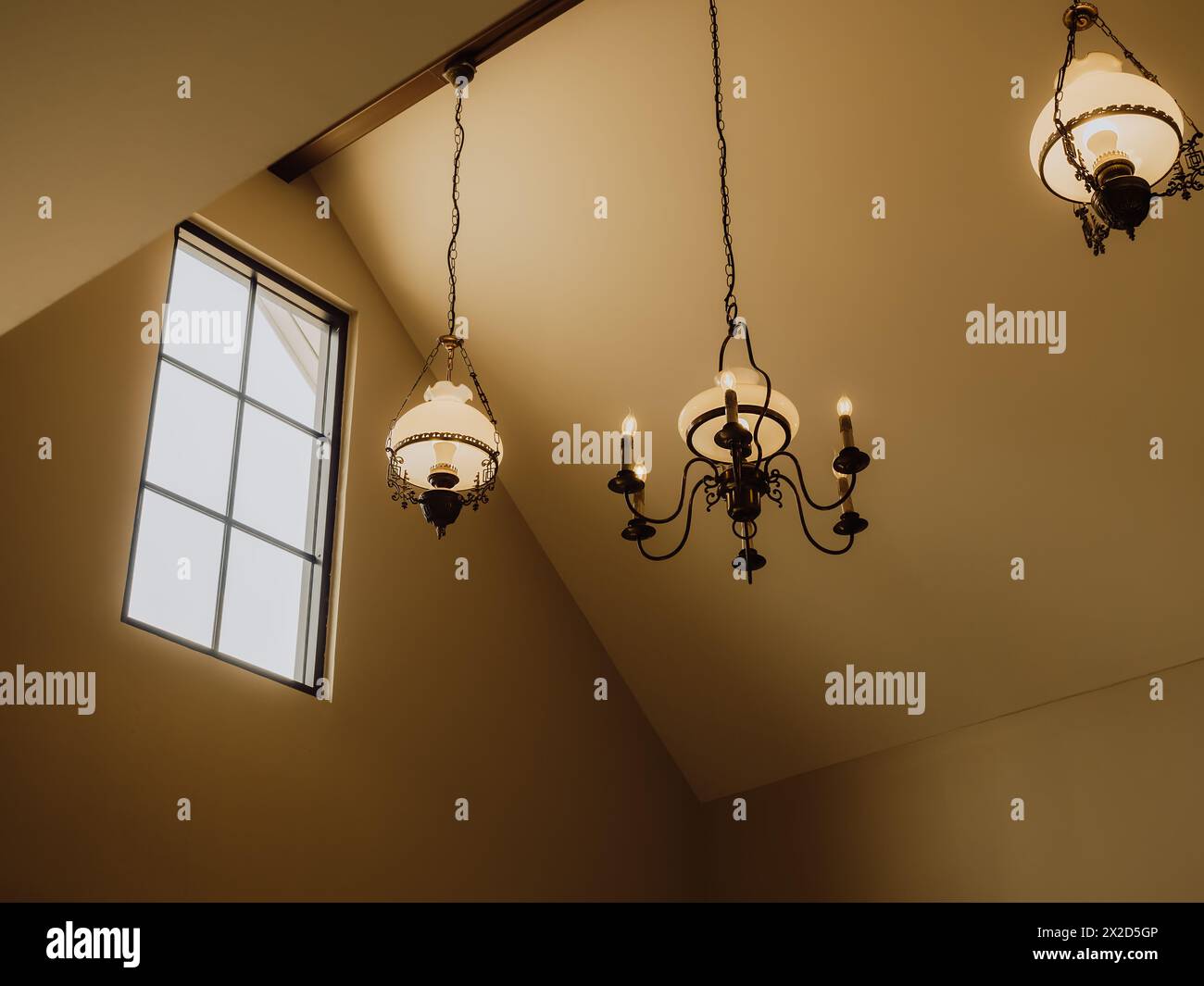 Vintage iron chandelier under the gable roof in the ancient house ...