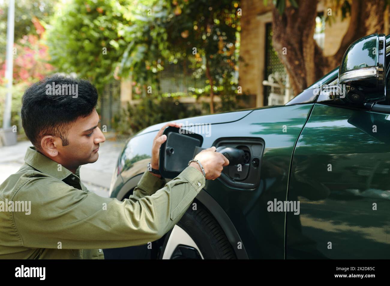 Indian electric car owner charging his vehicle Stock Photo - Alamy