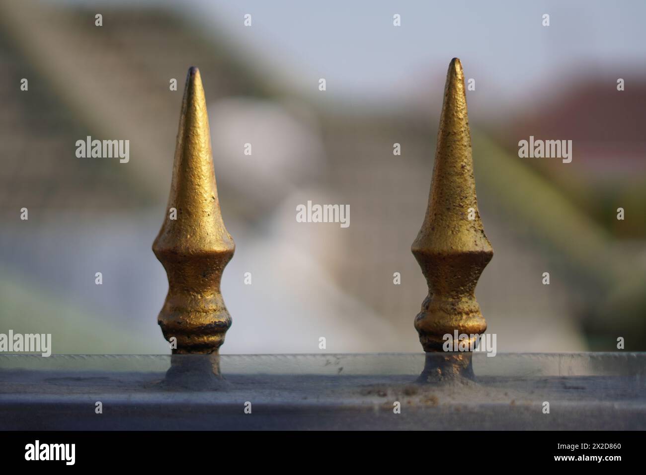 Two gold triangle-shaped objects with sharp ends and a blurred ...