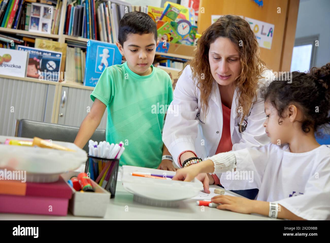 Teacher with children in a classroom of studies and games, Plant for ...