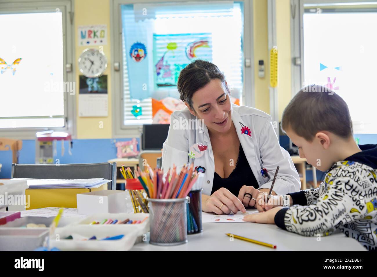 Teacher with children in a classroom of studies and games, Plant for ...