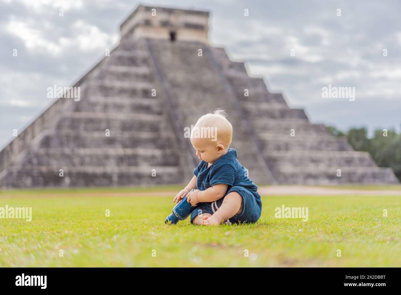 Baby traveler, tourists observing the old pyramid and temple of the ...