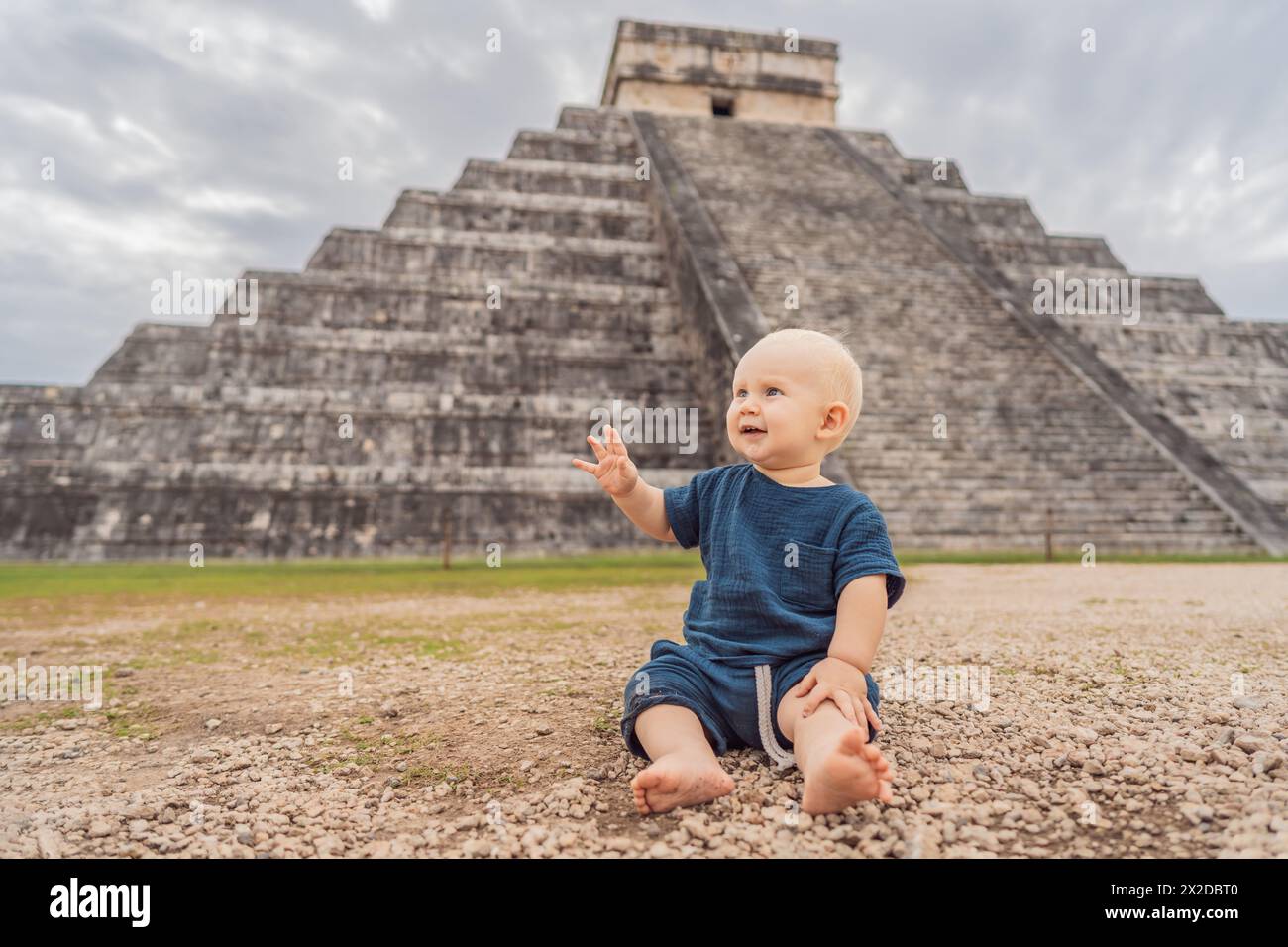 Baby traveler, tourists observing the old pyramid and temple of the ...