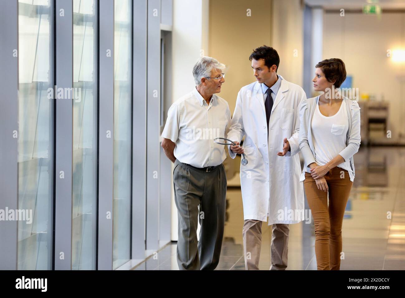 Doctor walking with patient in hospital corridor hi-res stock ...